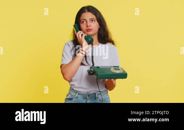 Tired bored Indian woman talking on wired vintage telephone of 80s ...