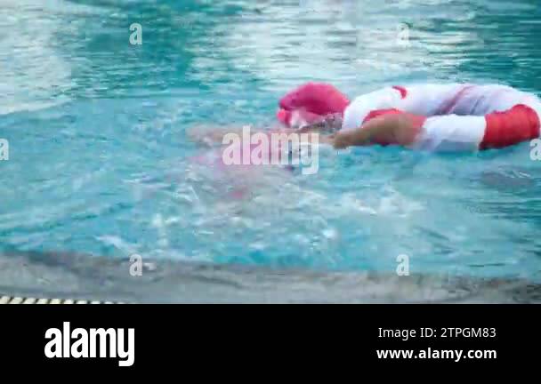 Little girl plays in the outdoor swimming pool of tropical resort ...