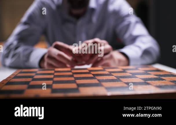strategic thinking, man puts a chess piece on a chessboard, close-up ...