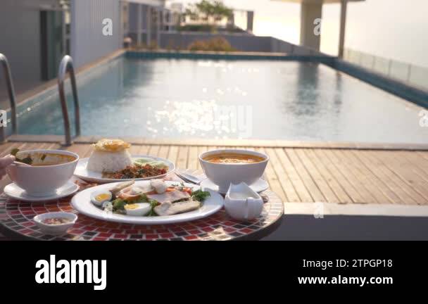 dishes of Thai cuisine. 4k. table by the pool. Thai traditional lunch ...