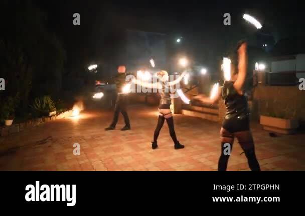 Fire performance show. Artists spin burning poles at night. Outdoor ...