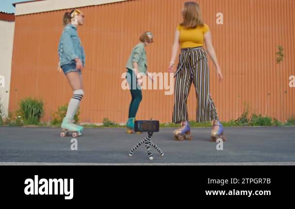 Ground level stable full shot of three millennial girls doing ...