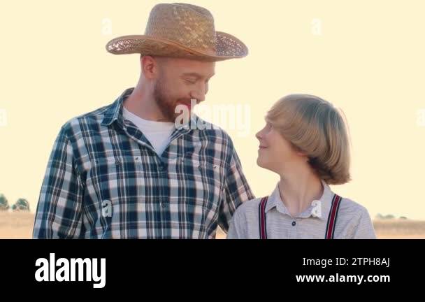 Horizontal shot. Cheerful man hugging boy. Smiling farmer and boy ...