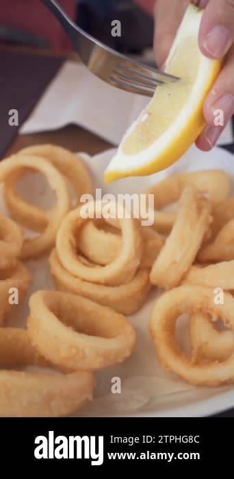 Spanish tapas: Adding lemon juice on Roman-style squid or fried ...