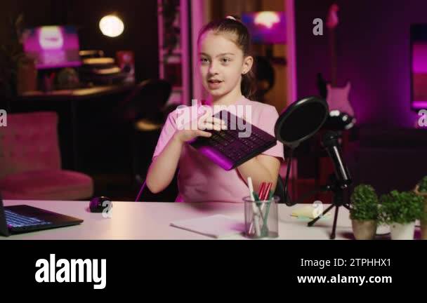 Kid content creator filming keyboard review in home studio, pressing different buttons to show ...