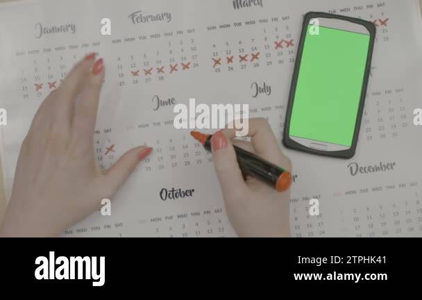 Top view of woman hands marking period dates on calendar planning birth ...