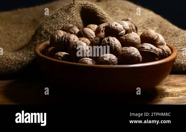 Walnut in the shell in a plate on the table. Strew the shell of nuts ...