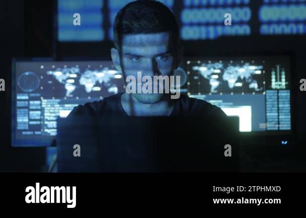 Male Hacker Programmer Working At Computer While Blue Code Characters Reflect On His Face In