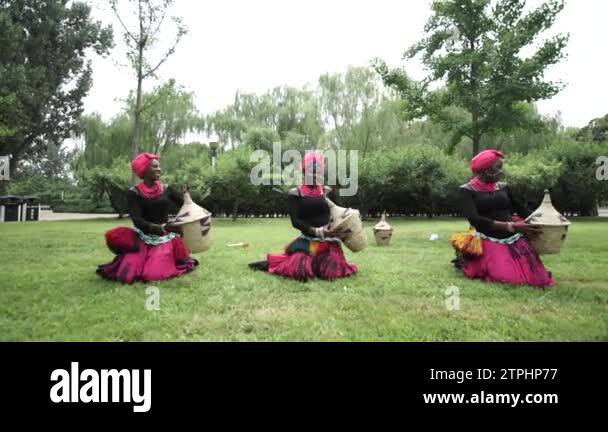 Three african women dancing a folk dance in traditional costumes with ...
