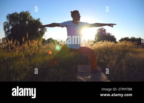 Close up of young guy practicing yoga moves and positions on mat at the ...