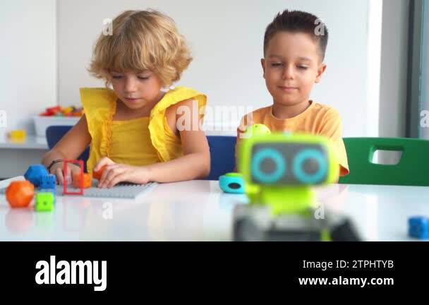 Elementary age kids playing with electronic toy car with joystick in ...