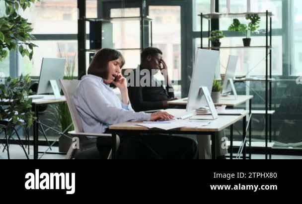 A multiracial entrepreneurial duo, feeling fatigued, shares a yawn ...