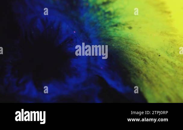 Ink drop. Paint splatter in water. Wet splash. Defocused yellow blue ...