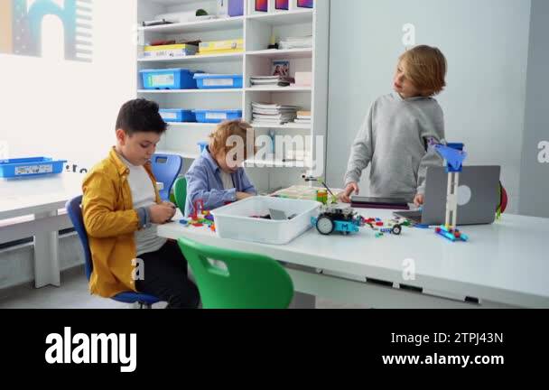 Robotics programming class. Children construct and code Robot. STEM education using constructor ...