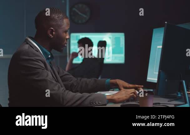Waist up of African American programmer coding on desktop computer while working in office at ...