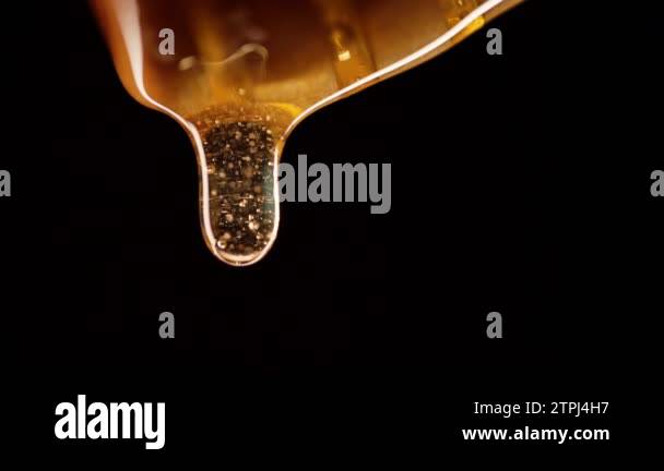 Organic honey flows from olive wood dipper stick spoon, tasty process ...