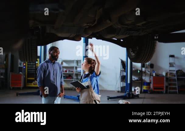 Qualified engineer in repair shop showing customer what needs to be ...