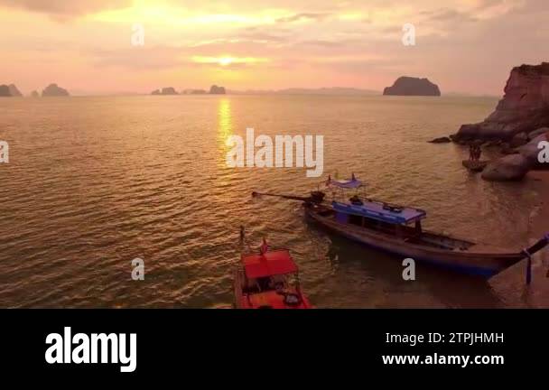 Long-tailed boats are waiting for tourists to visit the strangely shaped cape. The cape is pink ...