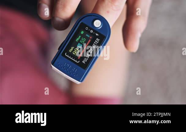 Man measures pulse and oxygen saturation with a pulse oximeter at home ...