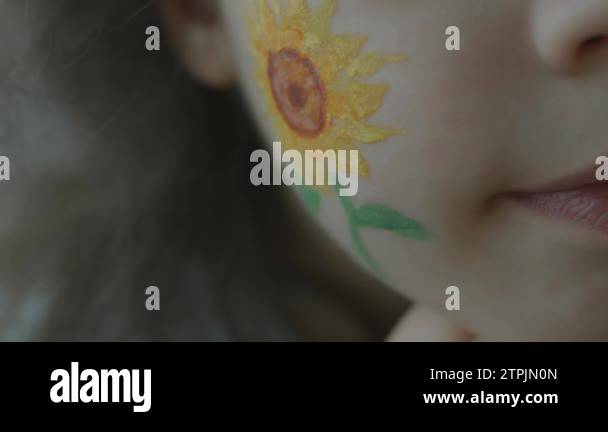 Sunflower drawing on the face of a happy little girl. Agriculture ...