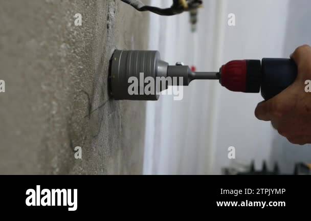 Handyman Drilling a socket in the wall, a male worker with a drill in ...