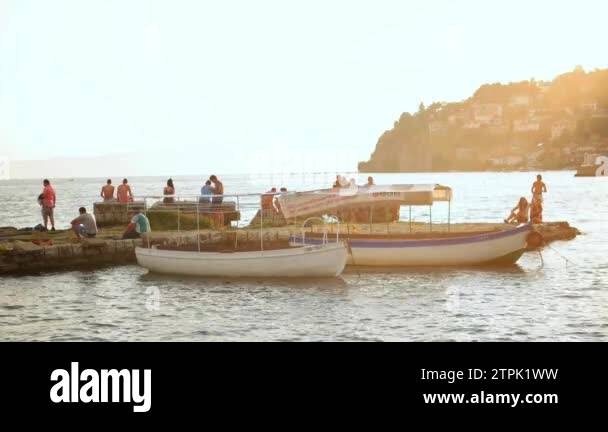OHRID, MACEDONIA, JUNE 2015: People chilling at Ohrid lake at sunset ...