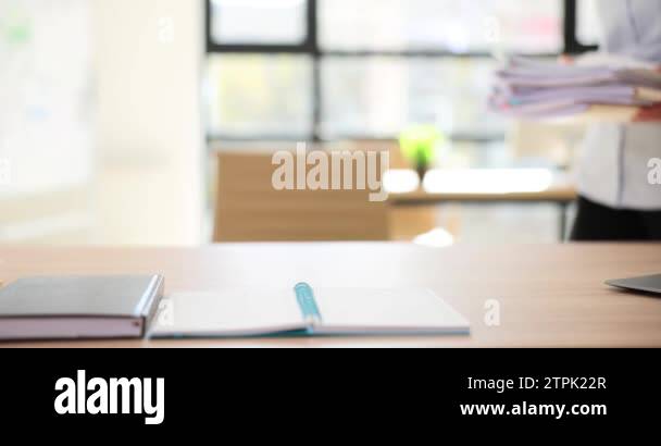 Female manager puts down as tack of office documents and leaves ...