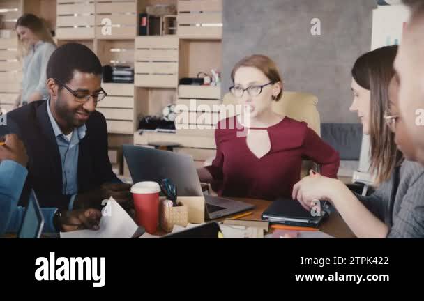 Multi ethnic team working on new project ideas. Happy office colleagues smiling at brainstorming ...