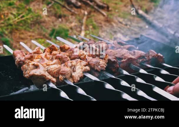 Kebab is fried on skewers in the grill and turned over. Juicy beautiful ...