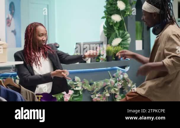 Man and woman having fun in thrift shop, filming commercial to lure ...