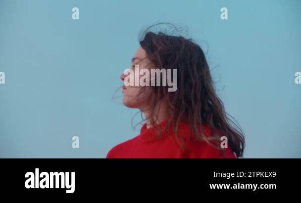 Cinematic and moody portrait of young beautiful woman in red sweater ...