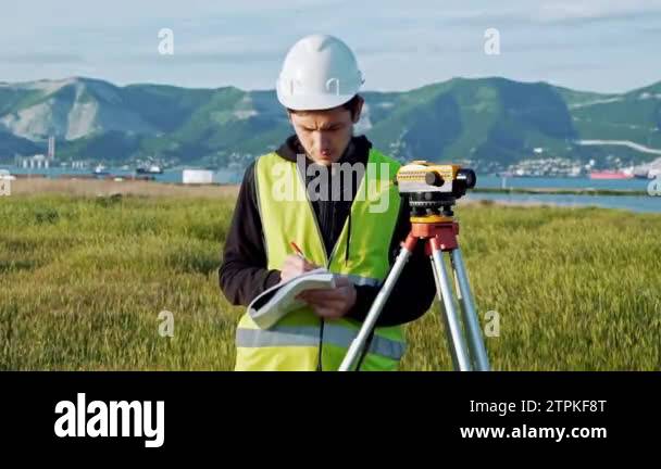 Surveyor engineer is measuring level on construction site. Geodesist ensure precise measurements ...