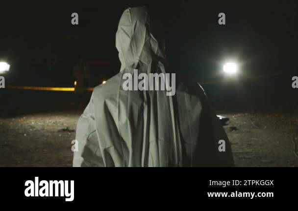 Back view following shot of anonymous forensic expert in protective ...
