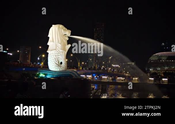 The dramatically lighted Merlion fountain. with a continuous spray of ...