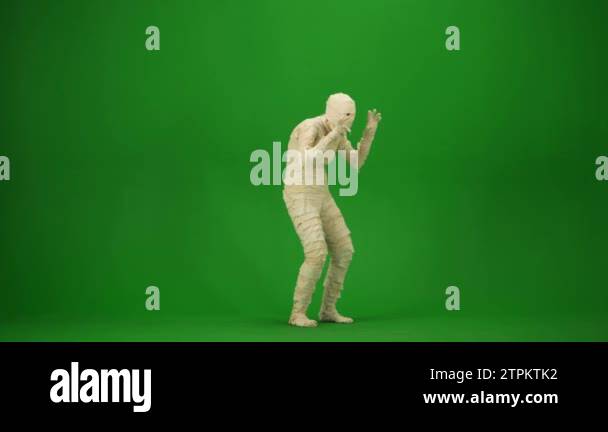 Scary mummy looks around, searches for a victim and scares with raised ...