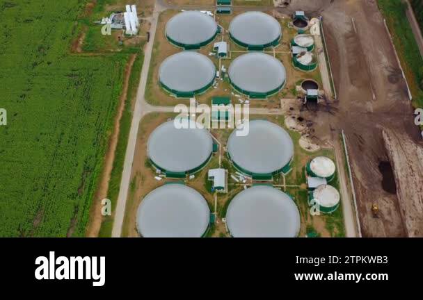 Modern biogas plant on field. Flying over the storage tanks for biomass ...