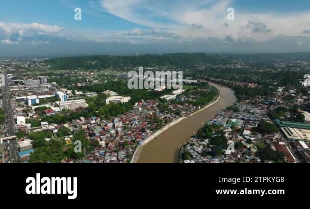 Downtown with buildings and houses in riverside. Blue sky and clouds. Davao City. Mindanao ...