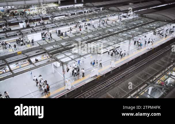 Crowd of people wait and board arriving train at subway station at ...