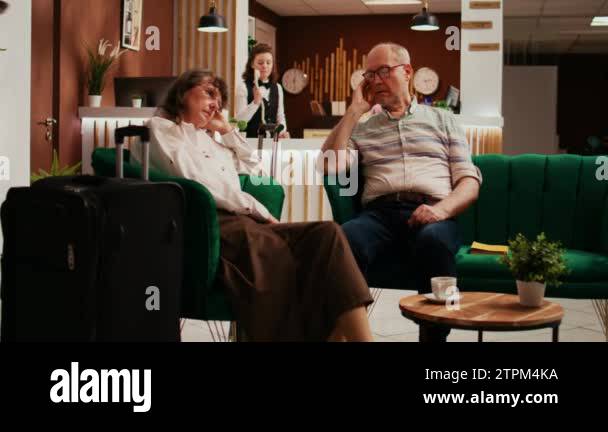 Sleepy elderly couple napping on sofa at hotel lobby, feeling exhausted ...