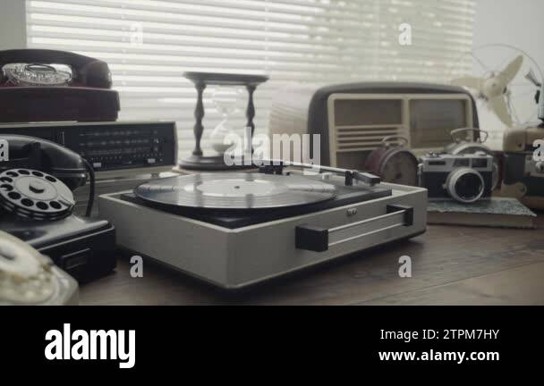 Man playing a vinyl record on a vintage record player and collection of ...