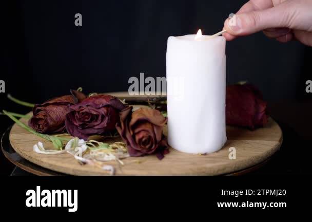 Hand Lights a White Candle against the Background of Rotating Dry Red ...