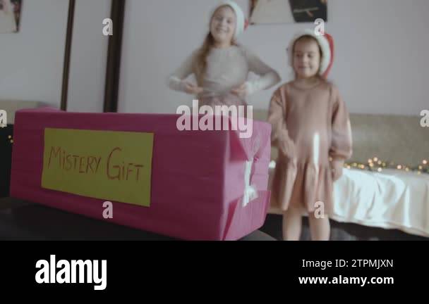Mystery gift box. Little girls show gestures guessing what is inside ...