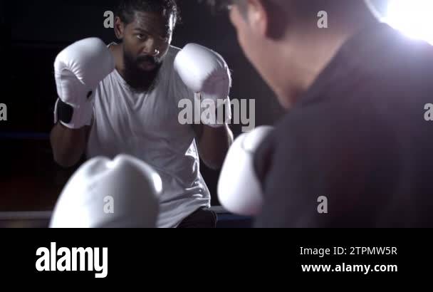 Two fighters facing each other inside boxing ring, rivals staring face ...