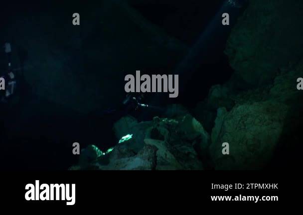 Swimming with flashlight in dark caves of Yucatan cenotes underwater in ...