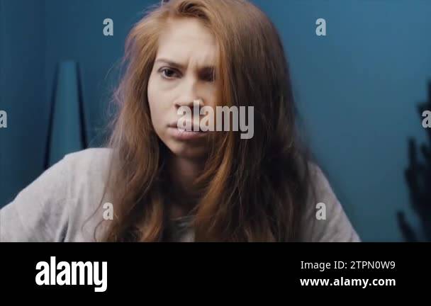 Drunk girl sits at kitchen trying to speak with boyfriend. Portrait of ...