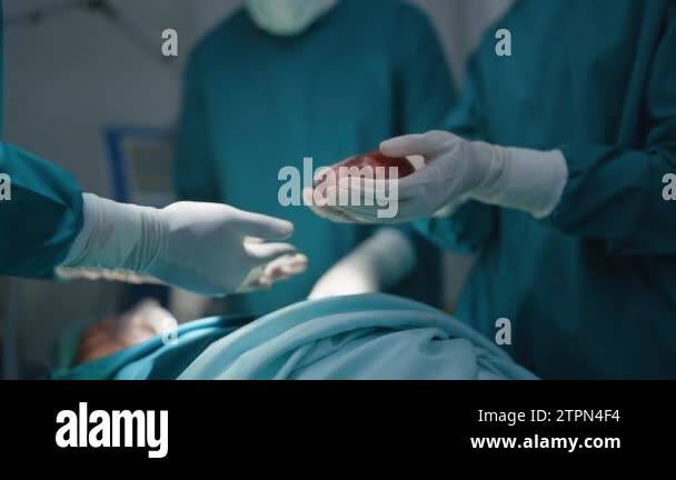 Team of surgeon doctors in operating room undergoing heart transplant ...