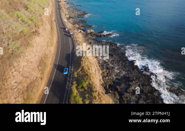 Aerial view electric convertible car driving on coastal road. Luxury ...