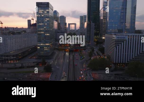 Busy multilane road and tunnel under modern urban district at sunset ...