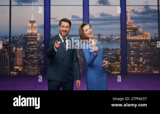 Two newscasters smiling broadcasting news at television media channel ...