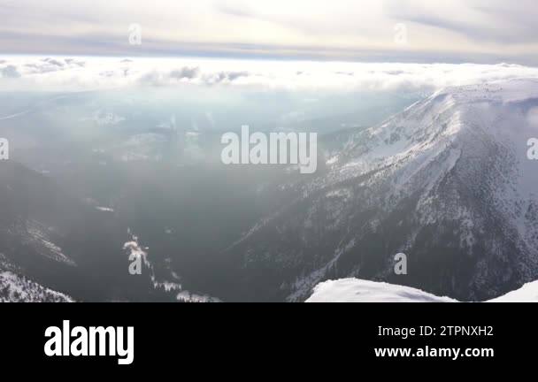 View of snow-capped mountain peaks. Clouds. Sunny day in the mountains ...